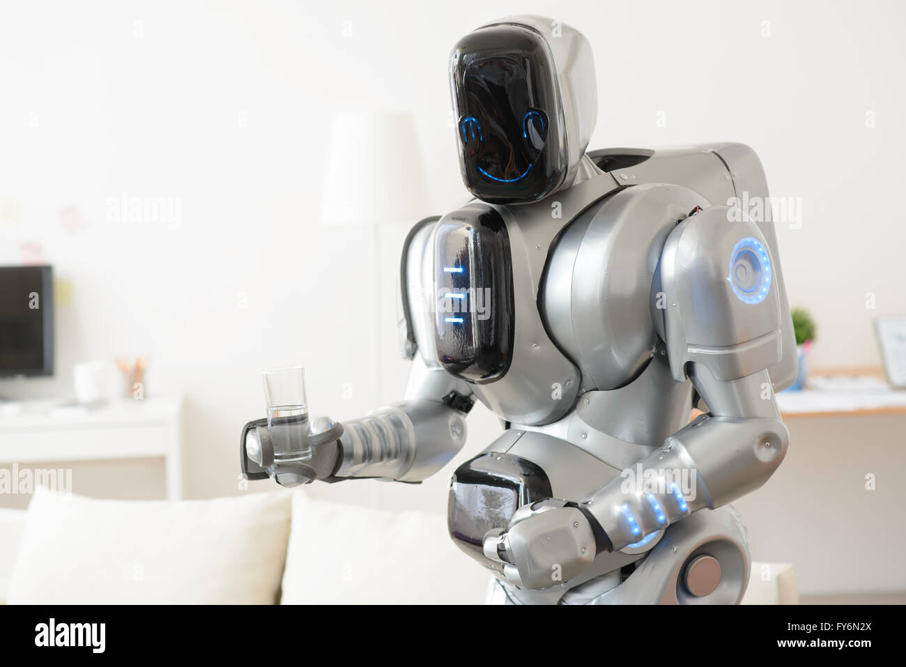 Positive robot holding glass of water Stock Photo - Alamy
