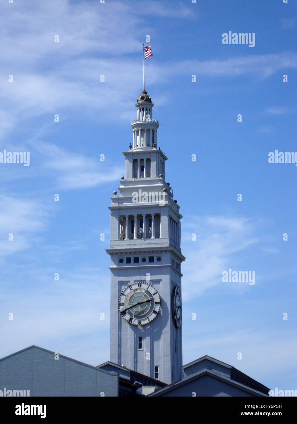 San Francisco Ferry building and clock tower with flag flapping in the ...