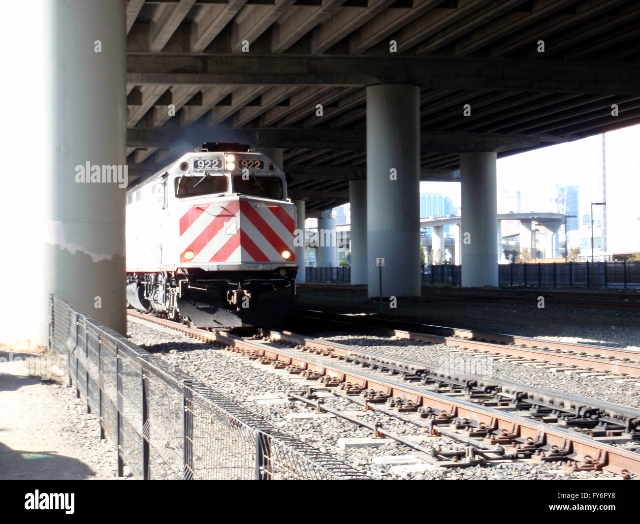 Caltrain Train moves along tracks under highway in San Francisco ...