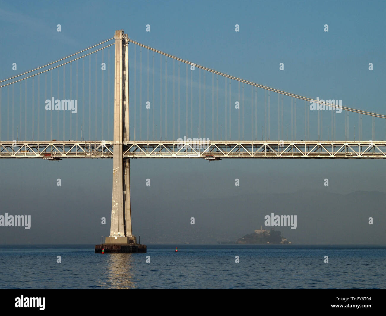 Sun shines on the Bay Bridge with Alcatraz island in the distance with ...
