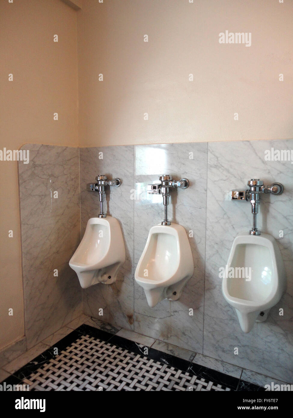 Three Men toilet Urinals in a tiled bathroom Stock Photo - Alamy