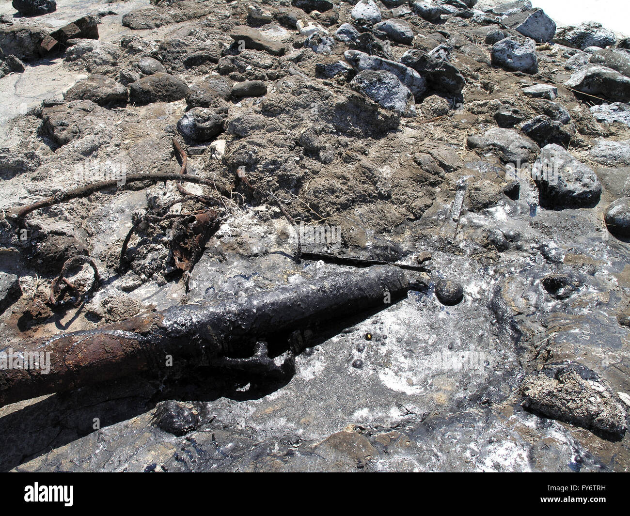 Oil covered pipe and bits of metal mix with lots of salt at the edge of ...