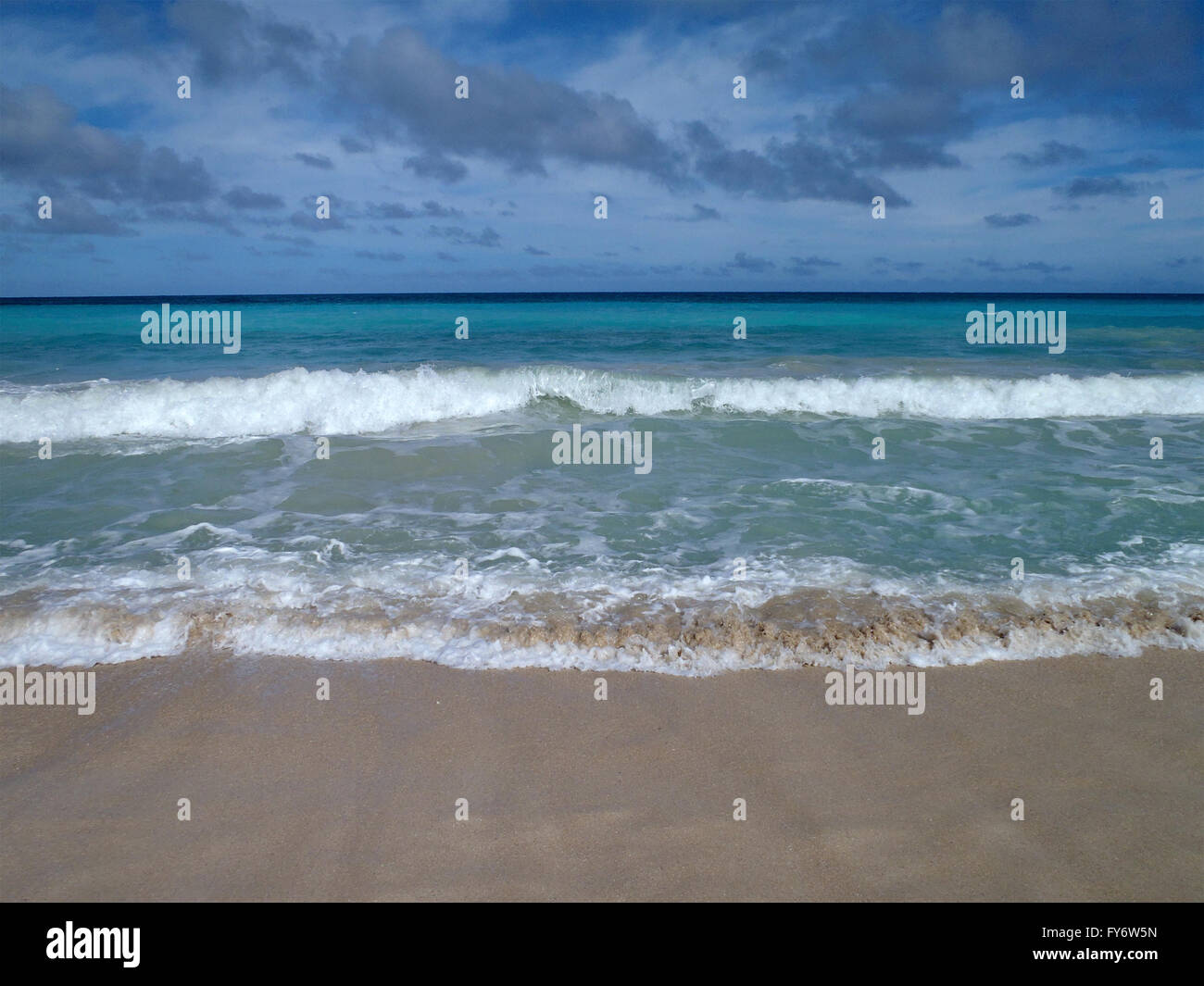 Dramatic wave sweeping away as another comes forward on a beach in Oahu ...