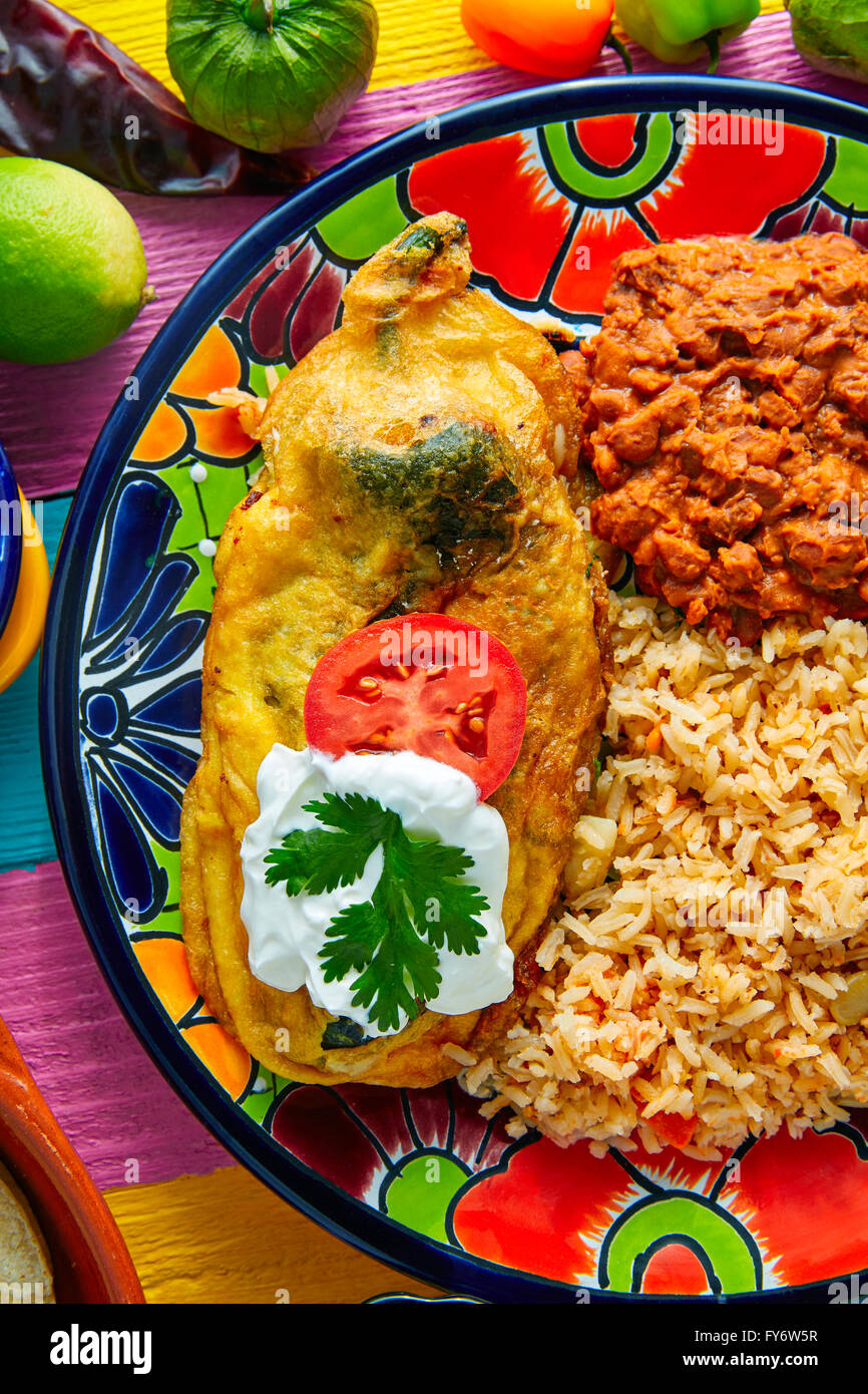 Chili relleno chili peppers filled with cheese in dish with with rice ...
