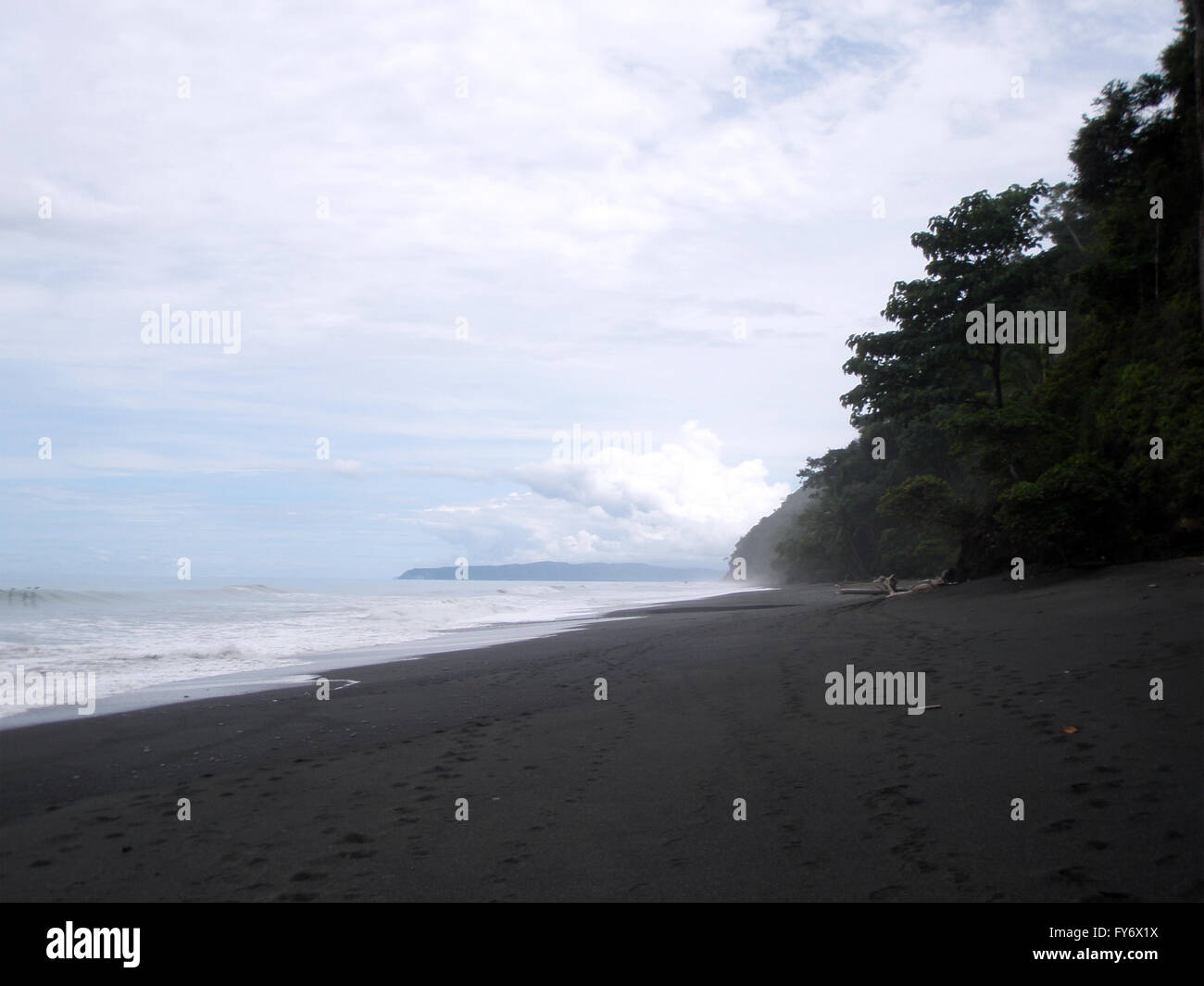 Remote dark sand beach with many tracks of foot prints in Punta Banco ...