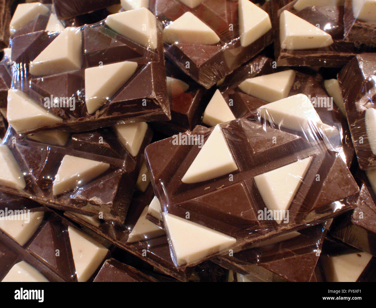 pile of plastic wrapped mix white and black chocolate bars on display ...