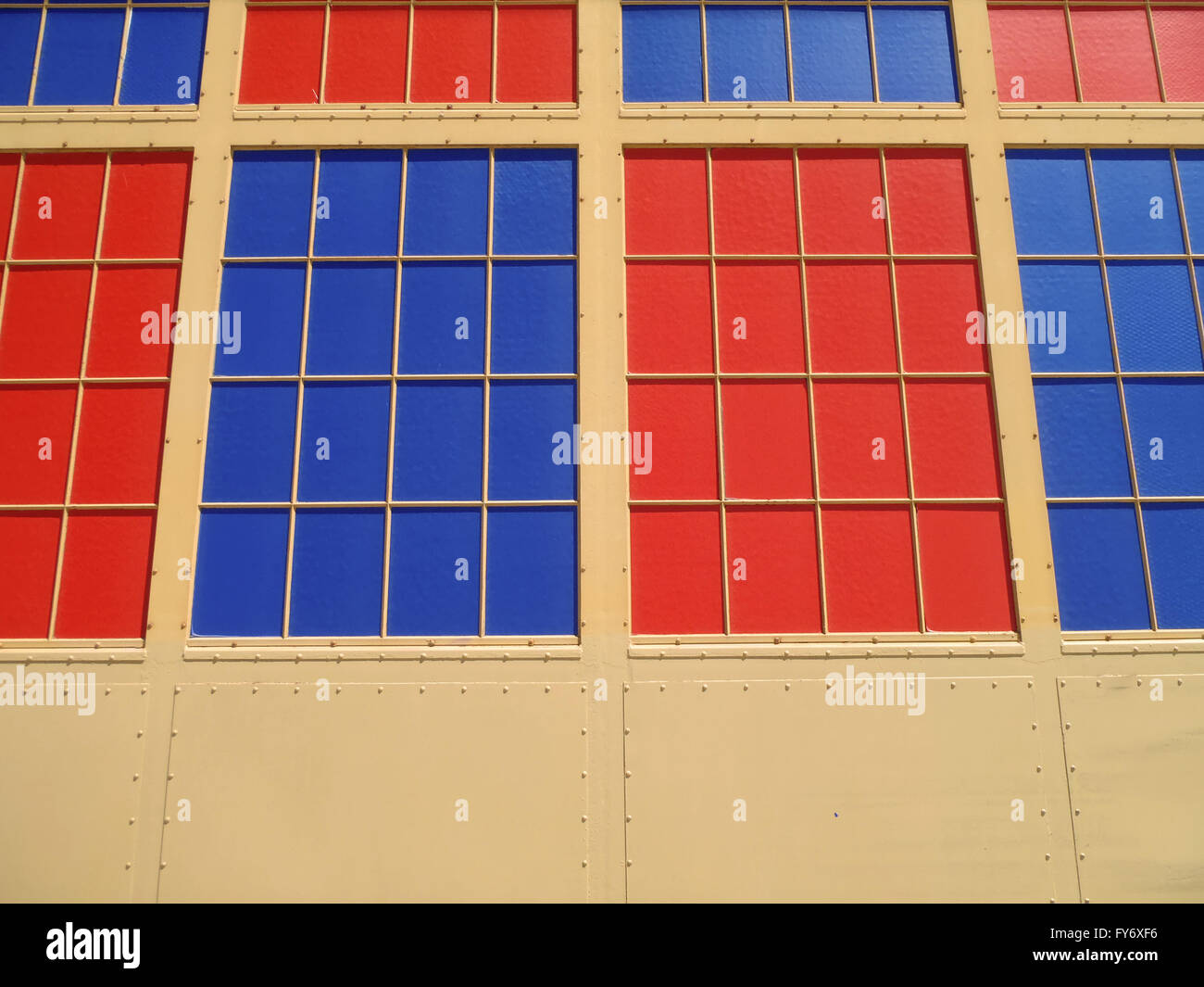 Red and Blue solid colored windows on an old fashion steel wall making ...