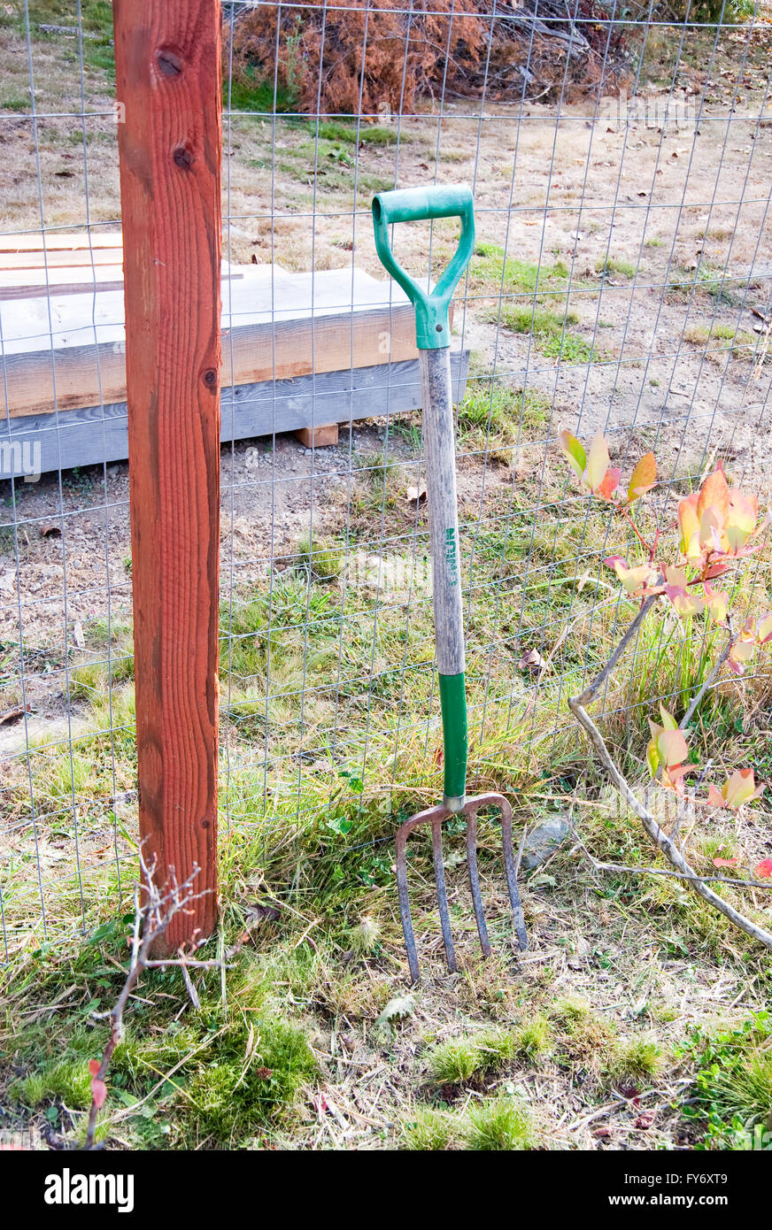 Rusty old pitchfork leaning against a fence Stock Photo - Alamy