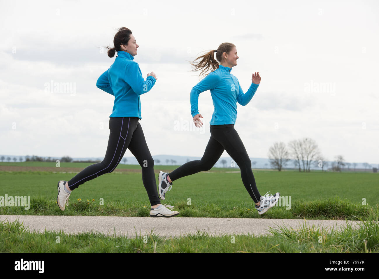 two women, 40 and 20 years old, jogging (running) outdoors Stock Photo ...
