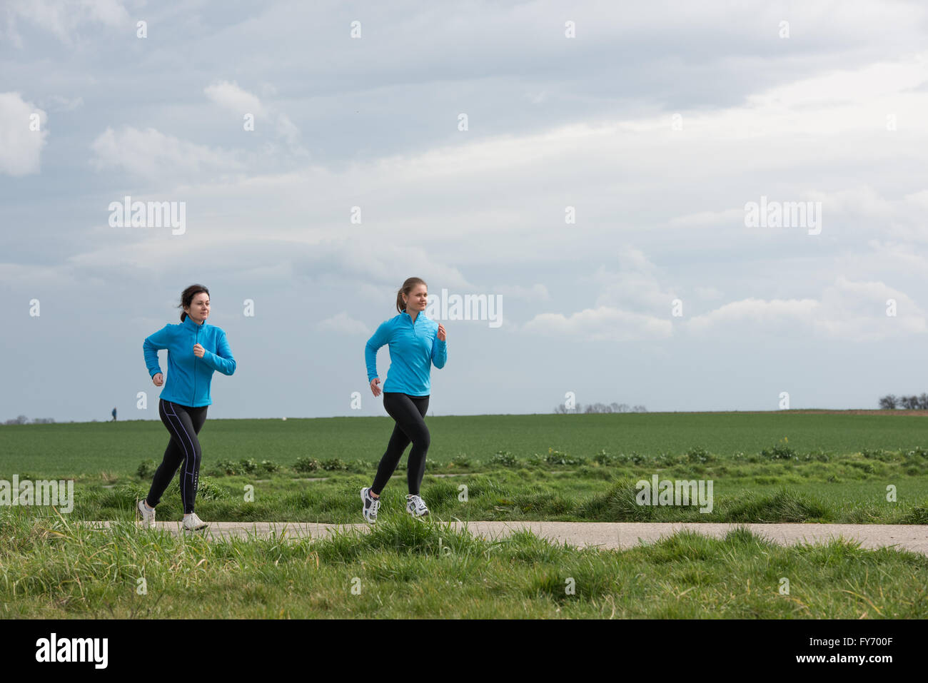 two women, 40 and 20 years old, jogging (running) outdoors Stock Photo ...