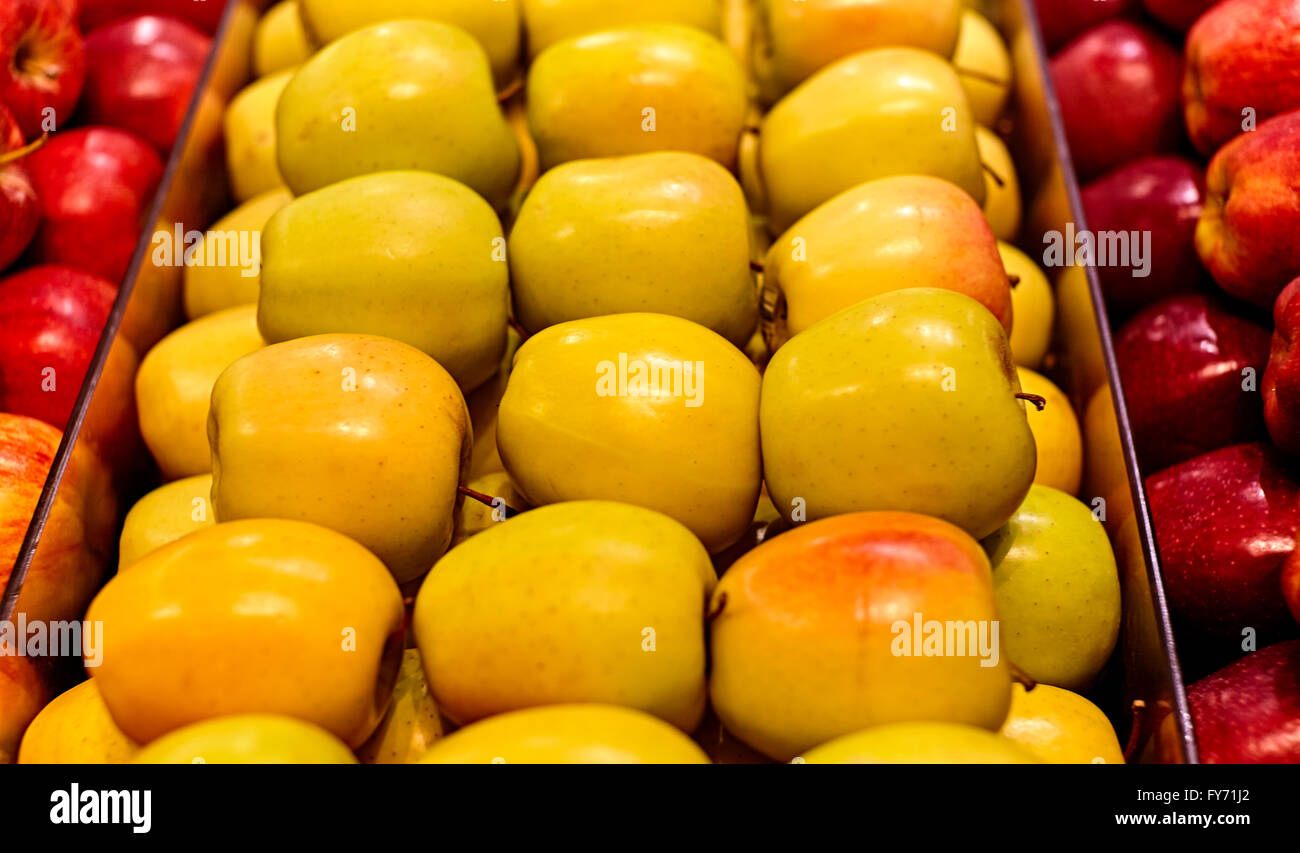 Bushel full of yellow apples in a row with red apples on the sides and ...