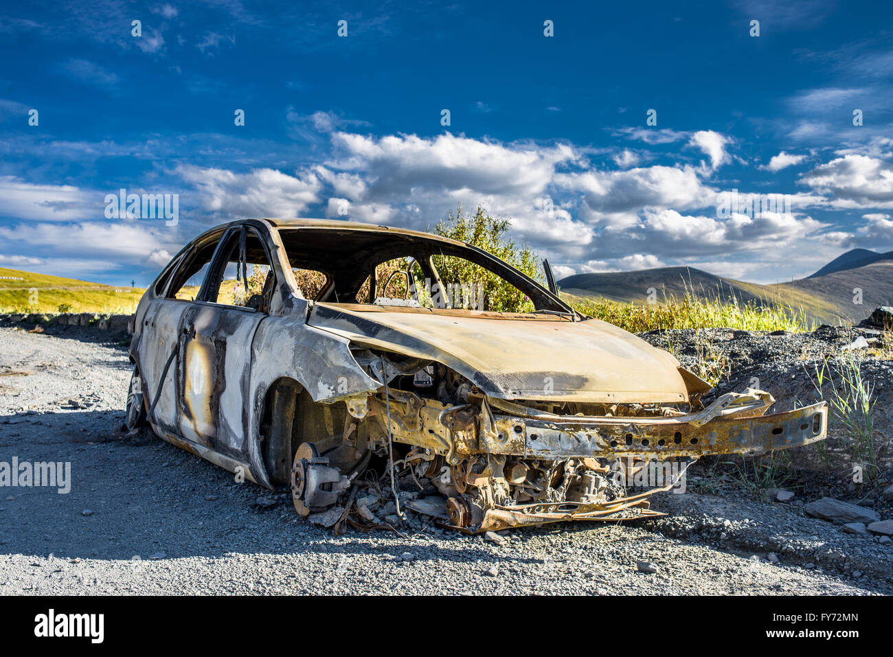 Burned car on the road Stock Photo - Alamy