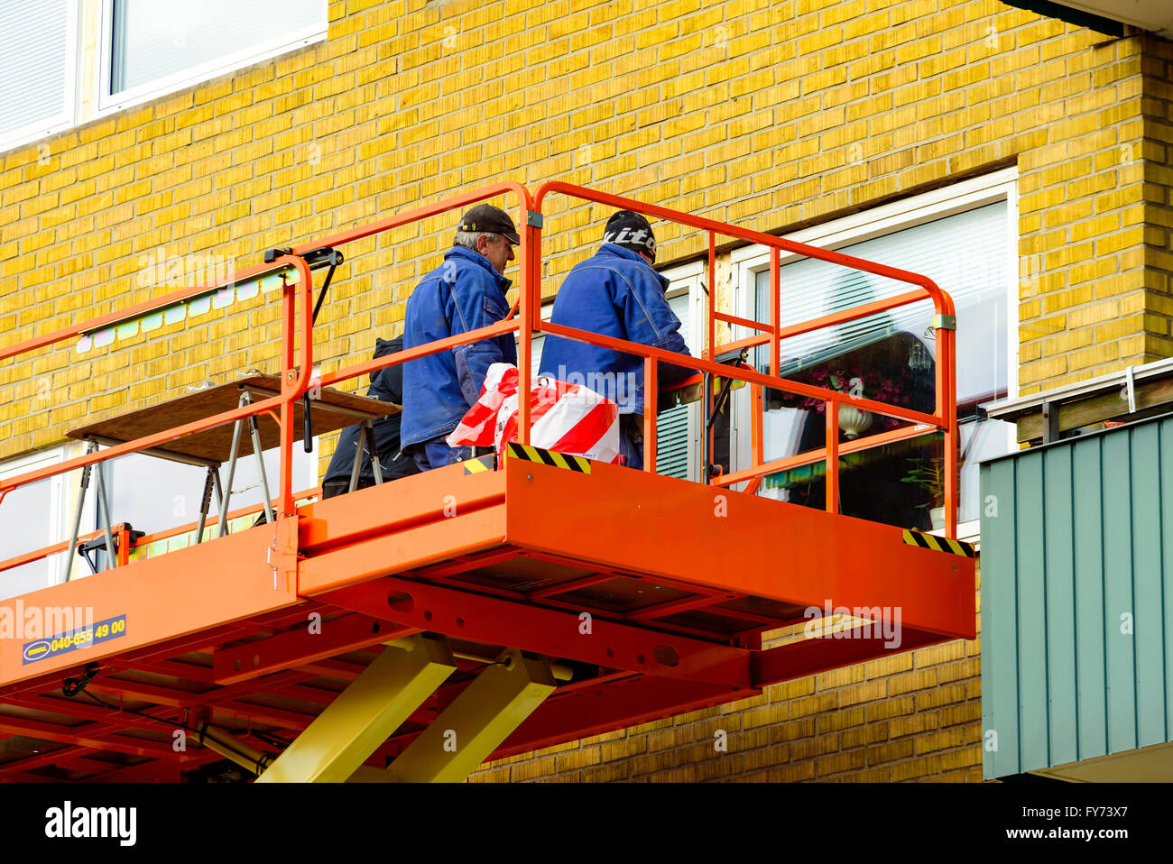 Trelleborg, Sweden - April 12, 2016: Workers on top of a Riwal scissor ...