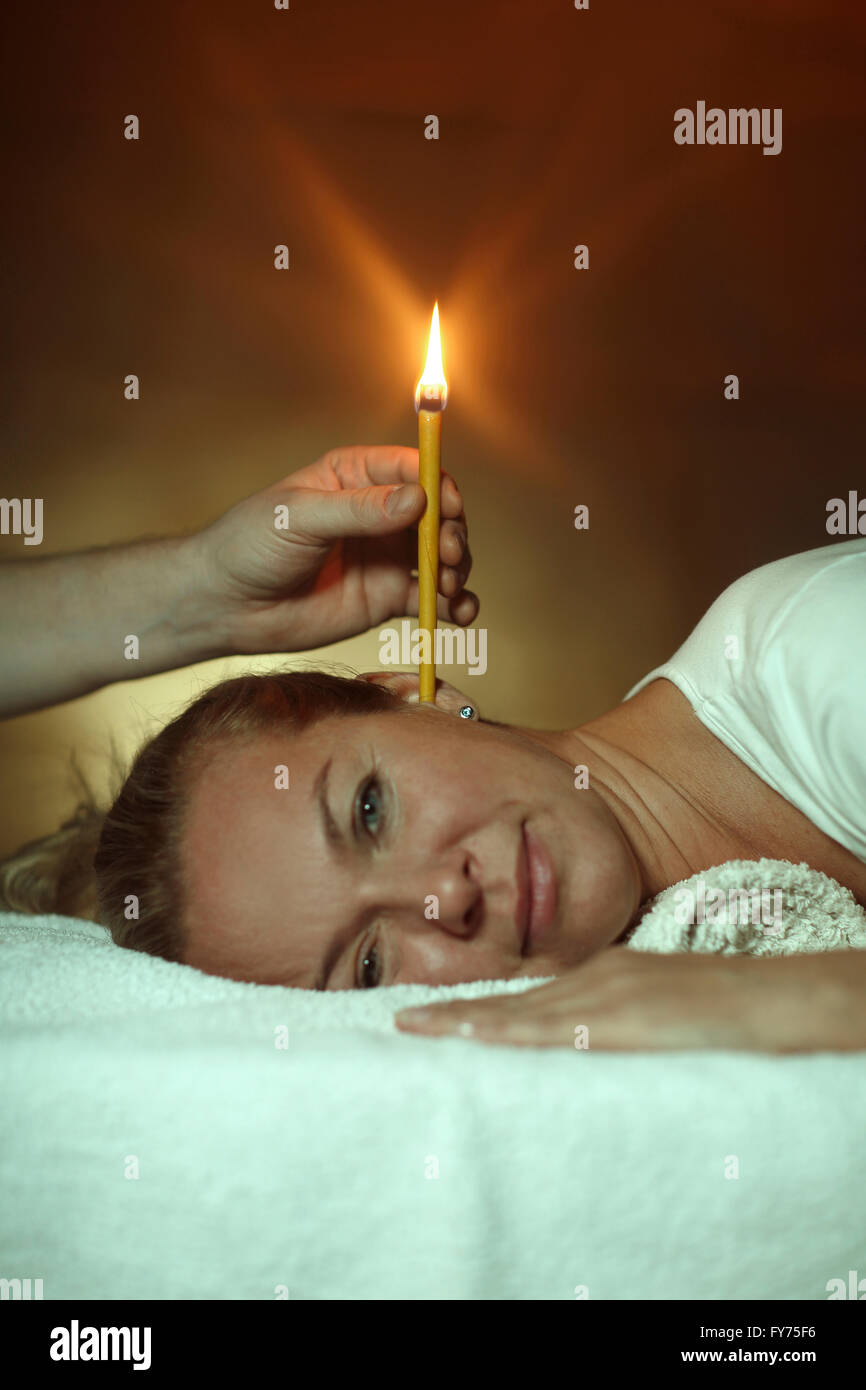 Woman, 44 years, is being treated with an ear candle Stock Photo - Alamy