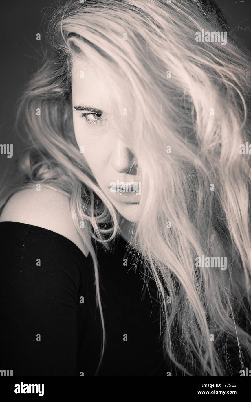 Young woman showing expression of cool attitude Stock Photo - Alamy