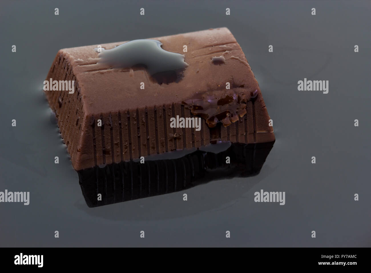 Single chocolate on liquid sweet chocolate Stock Photo - Alamy