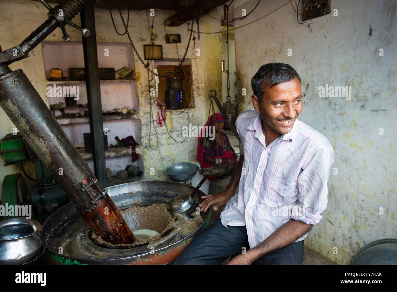 Man grinding seeds to make lotion in village of Chandelao, Rajistan ...