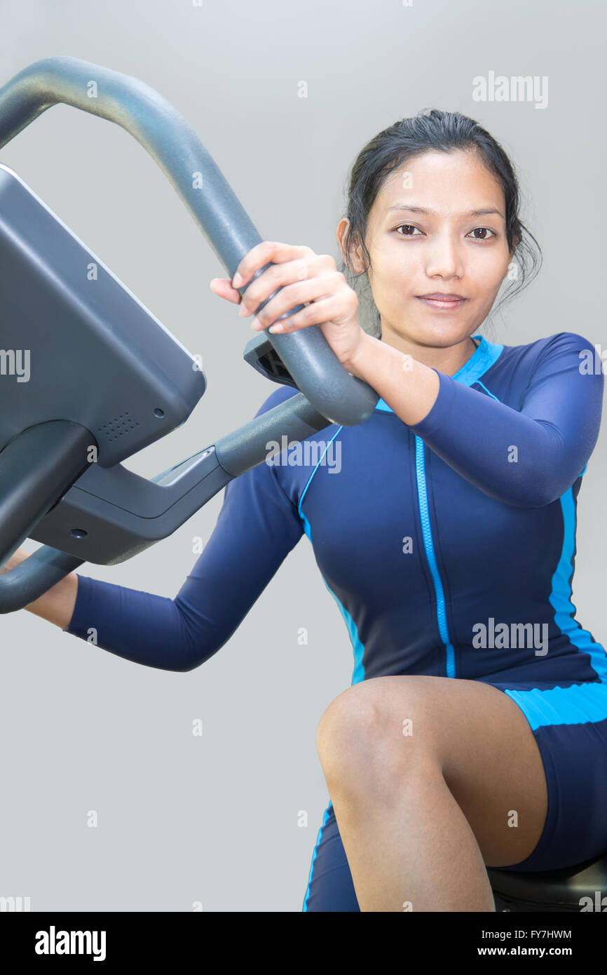 young woman riding an exercise bike at gym Stock Photo - Alamy