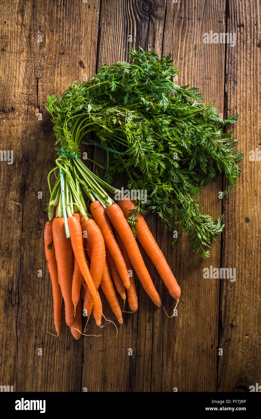 market fresh whole carrot bunch from overhead on wooden farmhouse table ...
