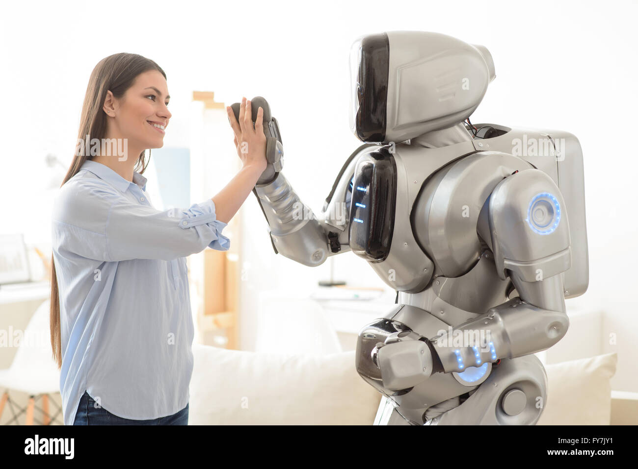 Positive girl and robot giving high five Stock Photo - Alamy