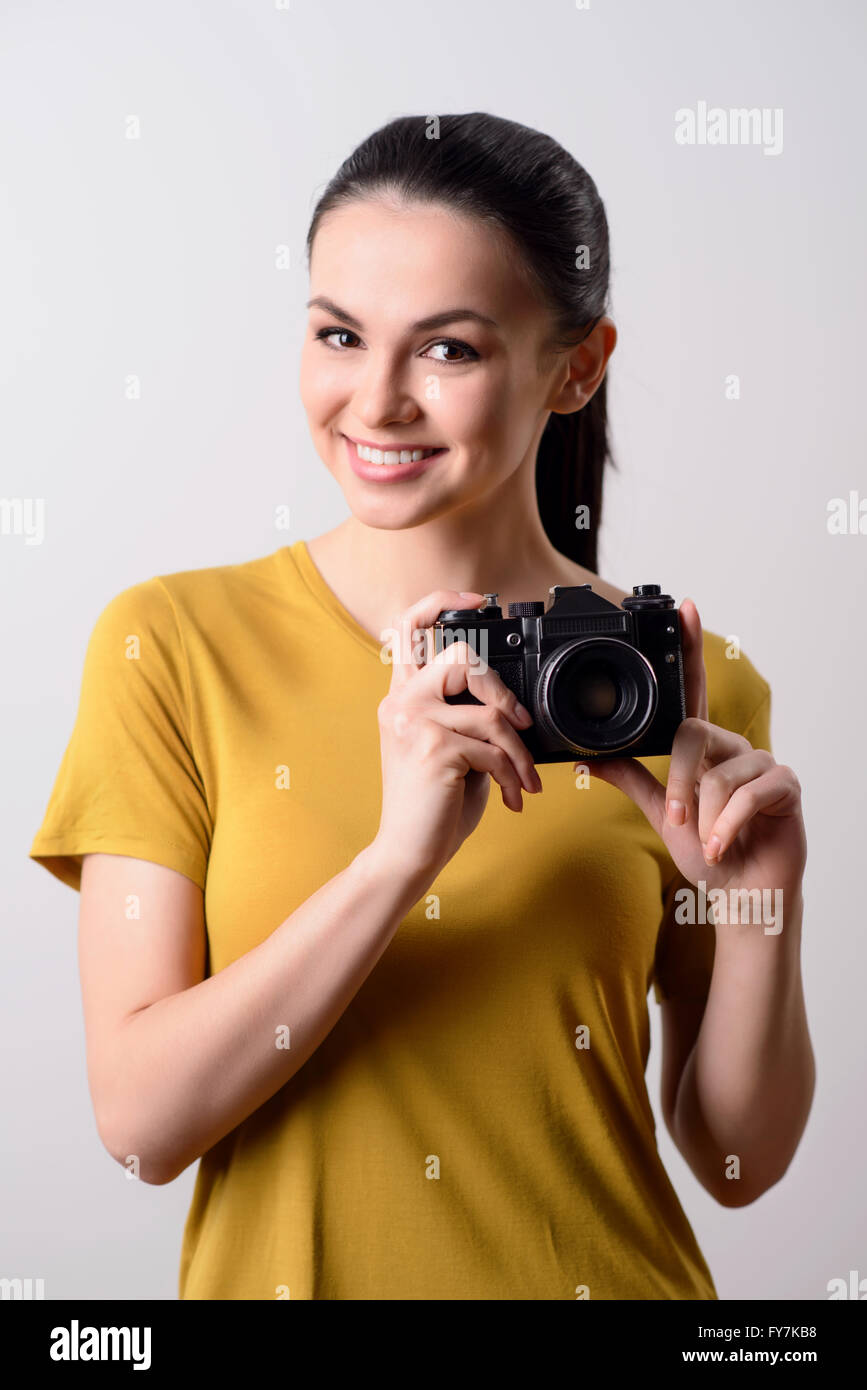 Positive girl holding photo camera Stock Photo - Alamy