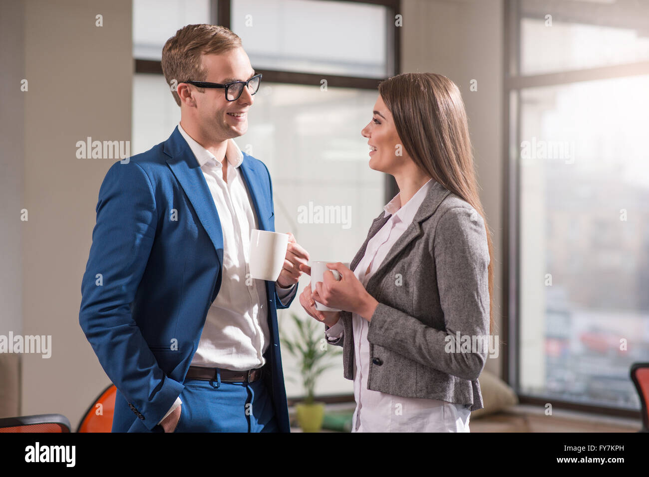 Positive colleagues drinking coffee in the office Stock Photo - Alamy