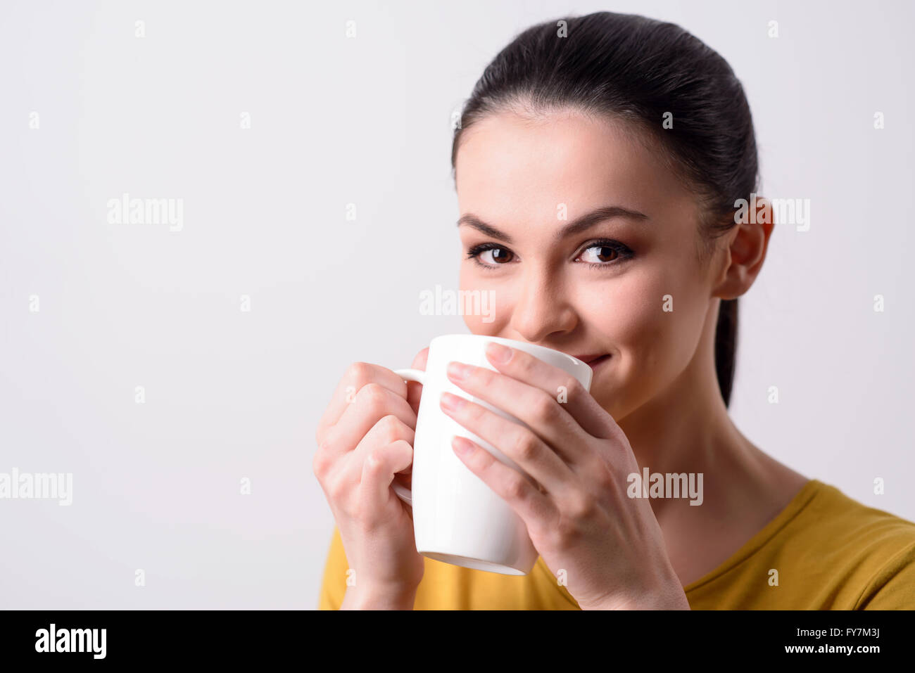 Positive girl drinking tea Stock Photo - Alamy