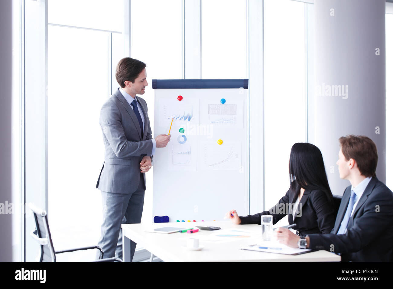 Workers at business meeting looking at presentation of financial ...