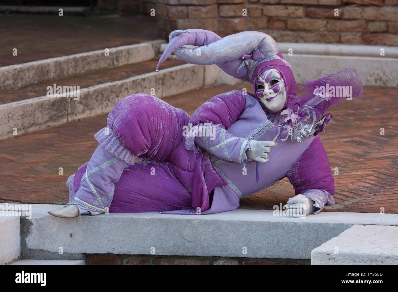 Lying down mask posing for portrait; Venice carnival Stock Photo - Alamy