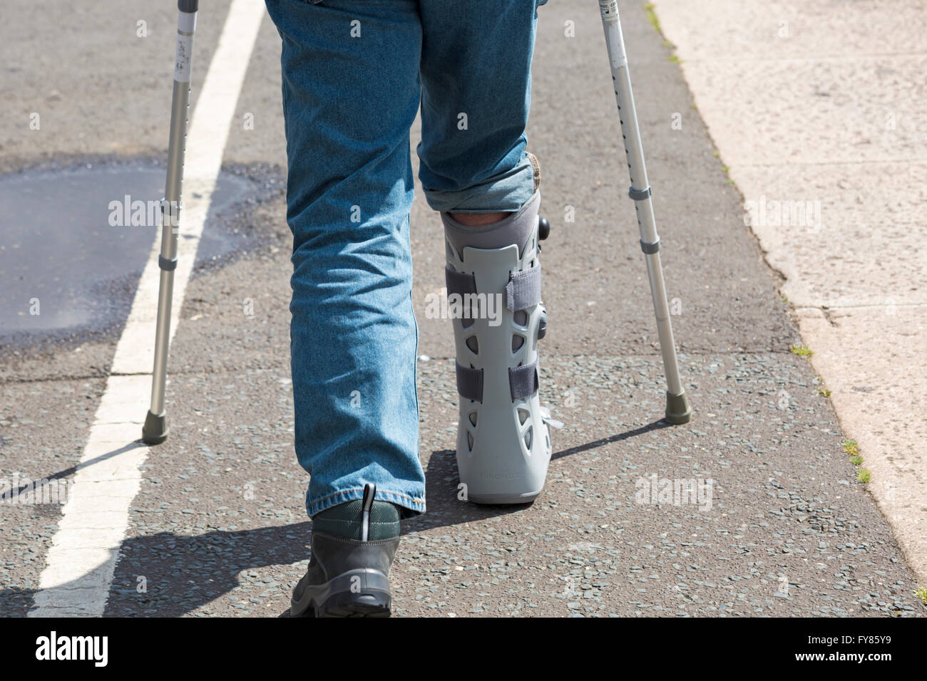 man walking with crutches and walking brace Stock Photo - Alamy