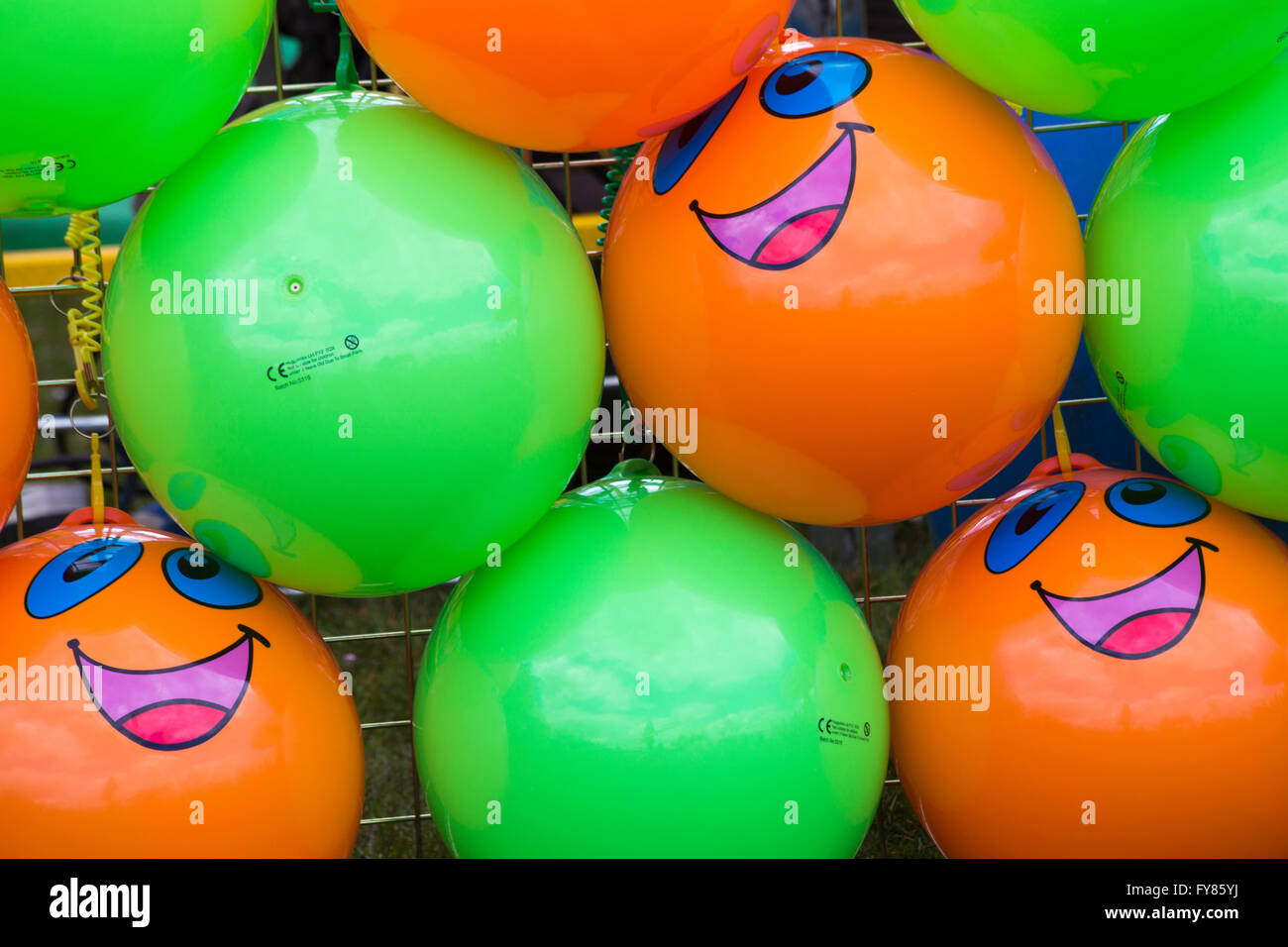Green and orange balls with smiley faces on display Stock Photo - Alamy