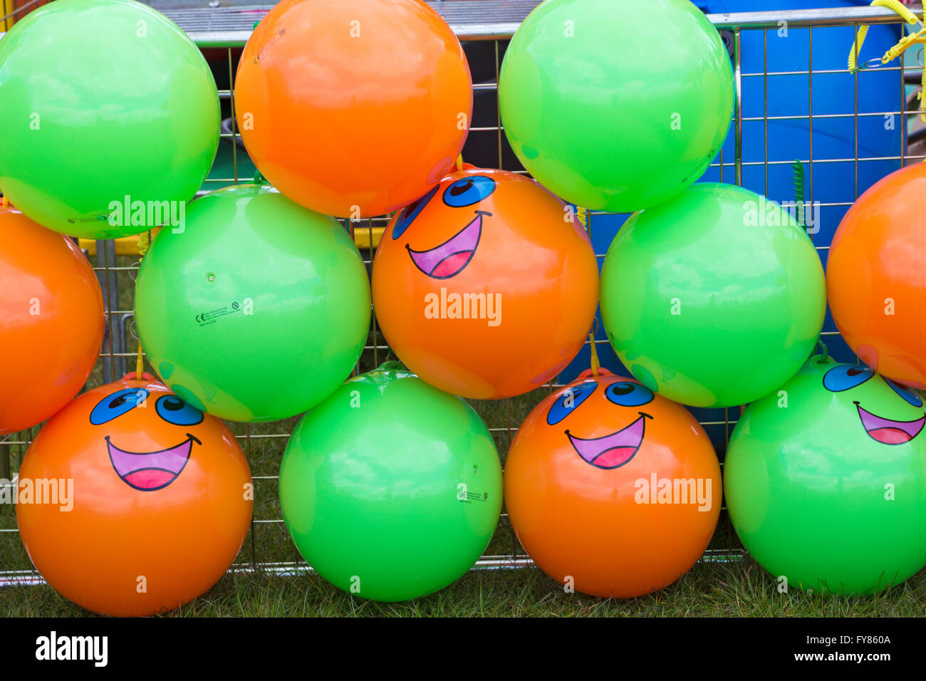Green and orange balls with smiley faces on display Stock Photo - Alamy