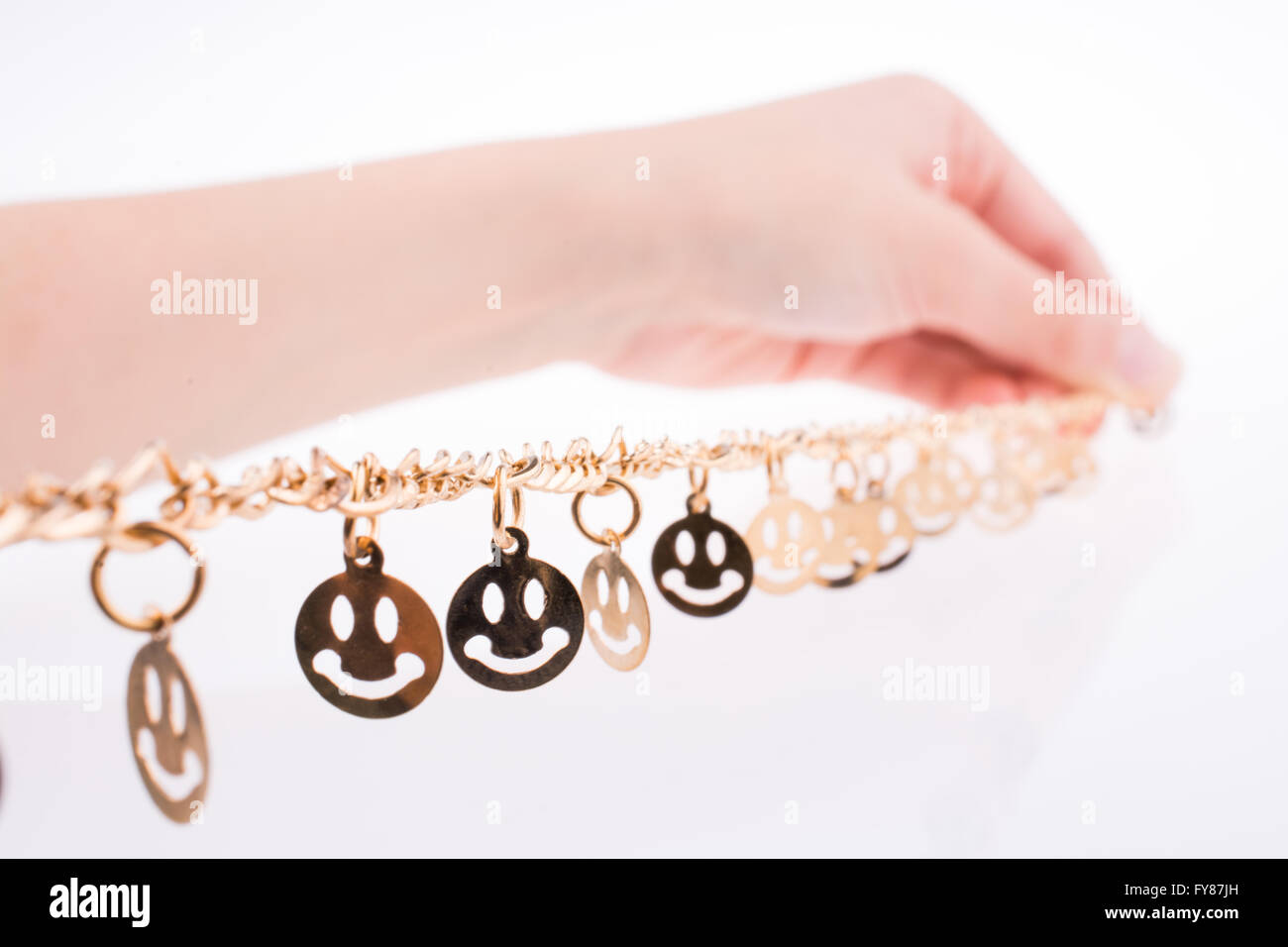 Golden color smileys arrayed on a chain in hand Stock Photo - Alamy