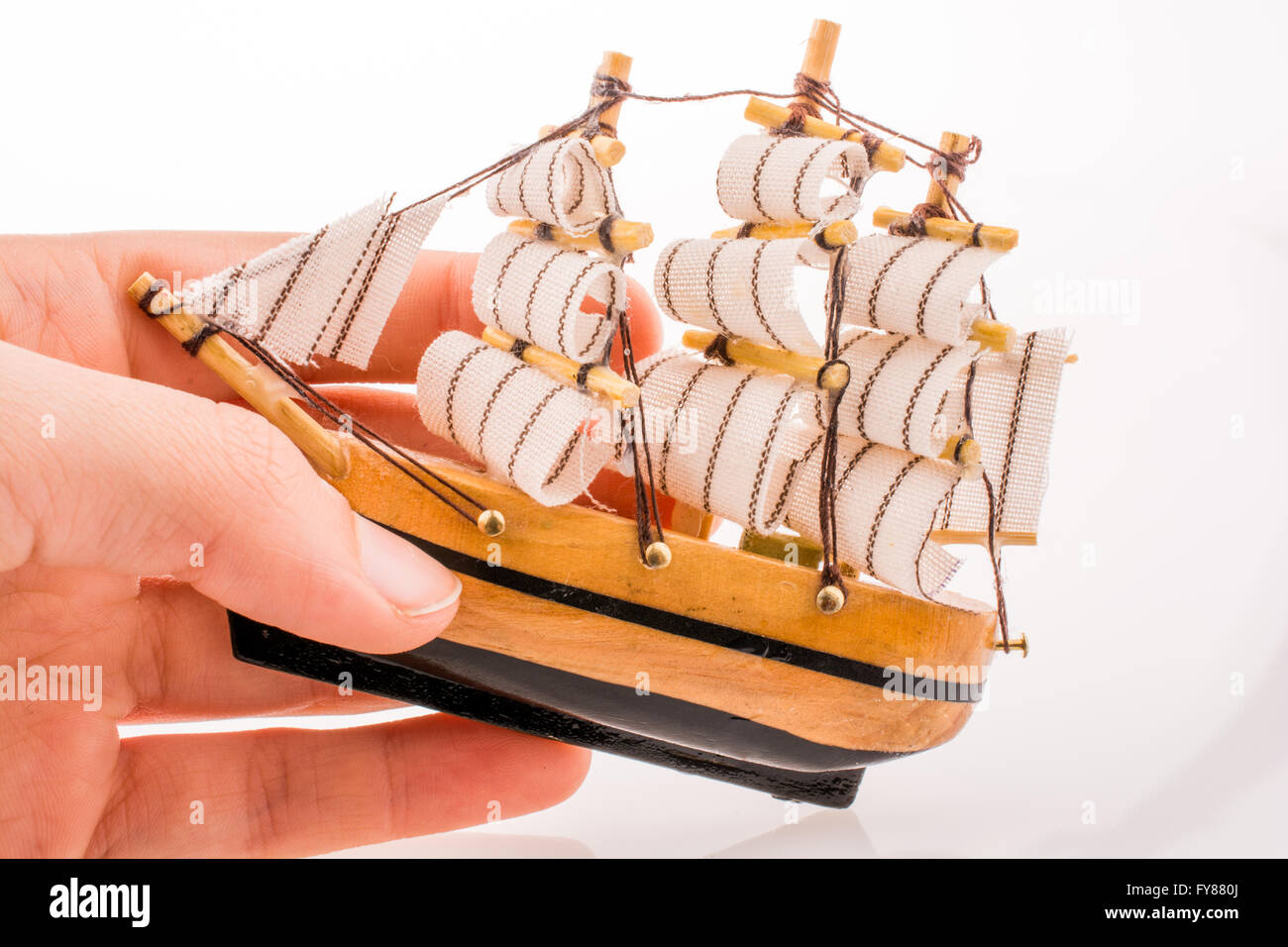Hand holding a Little model sailboat on a white background Stock Photo ...