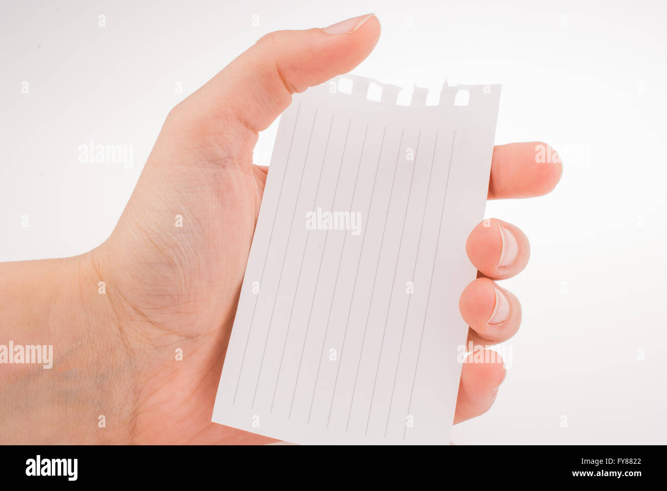 Hand holding a piece of lined paper on a white background Stock Photo ...
