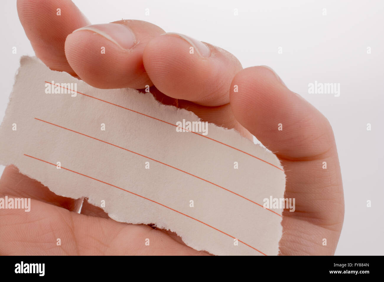 Hand holding a piece of torn lined paper on a white background Stock ...