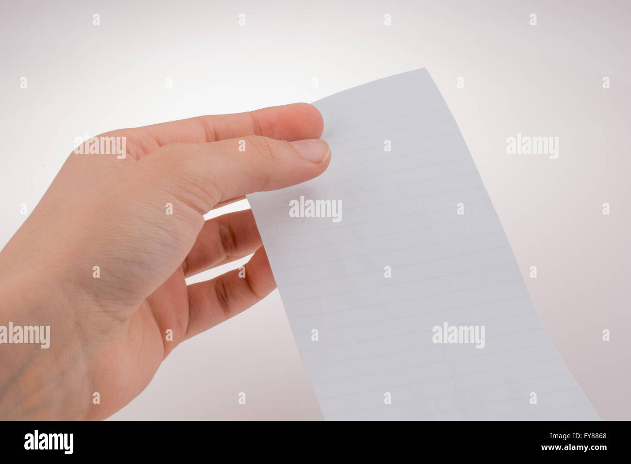 Hand holding a piece of paper on a white background Stock Photo - Alamy