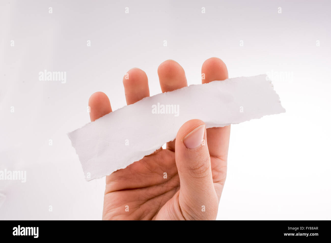 Hand holding a piece of paper on a white background Stock Photo - Alamy