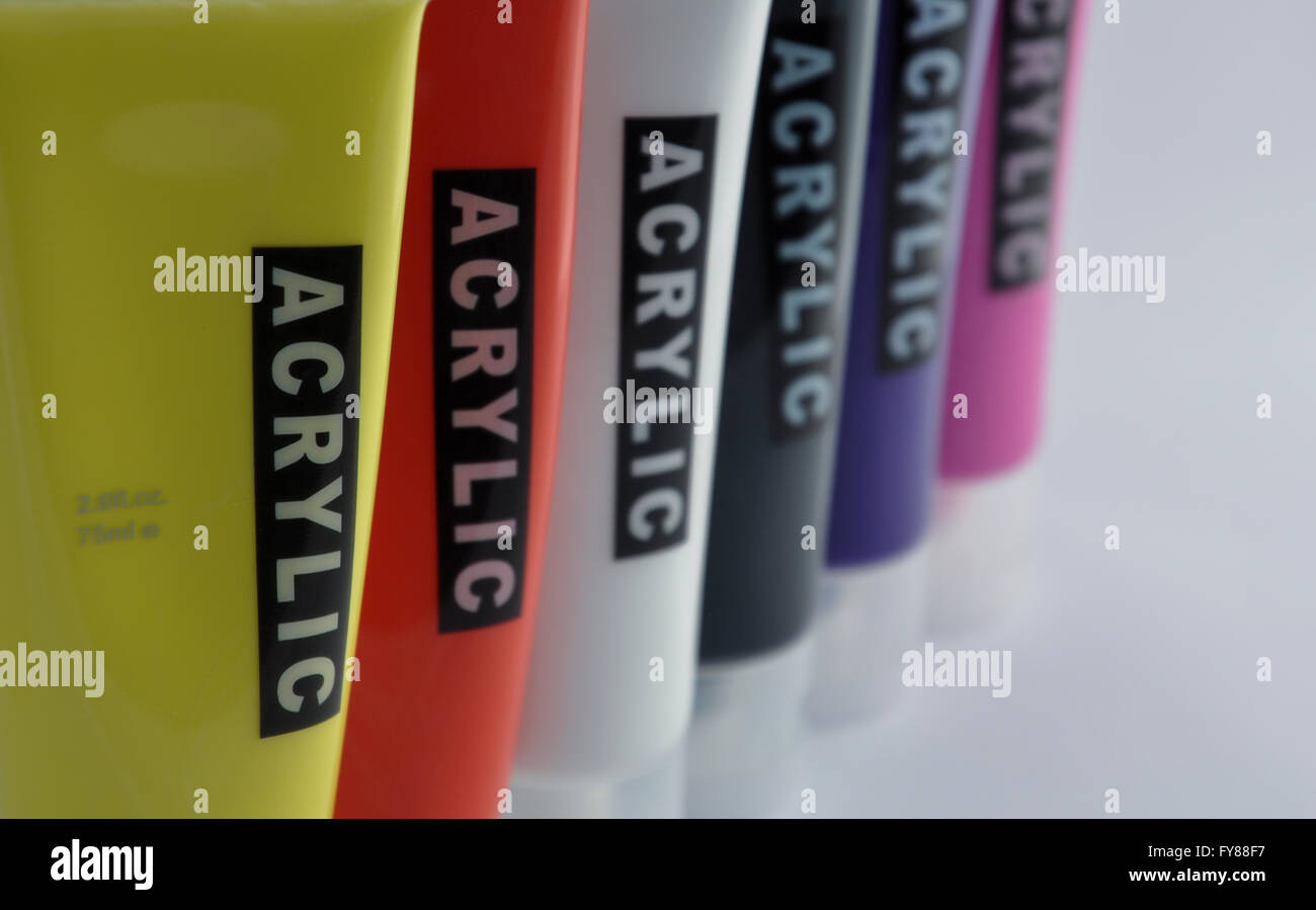 Multicoloured acrylic paint in a tube on a white background, selective ...