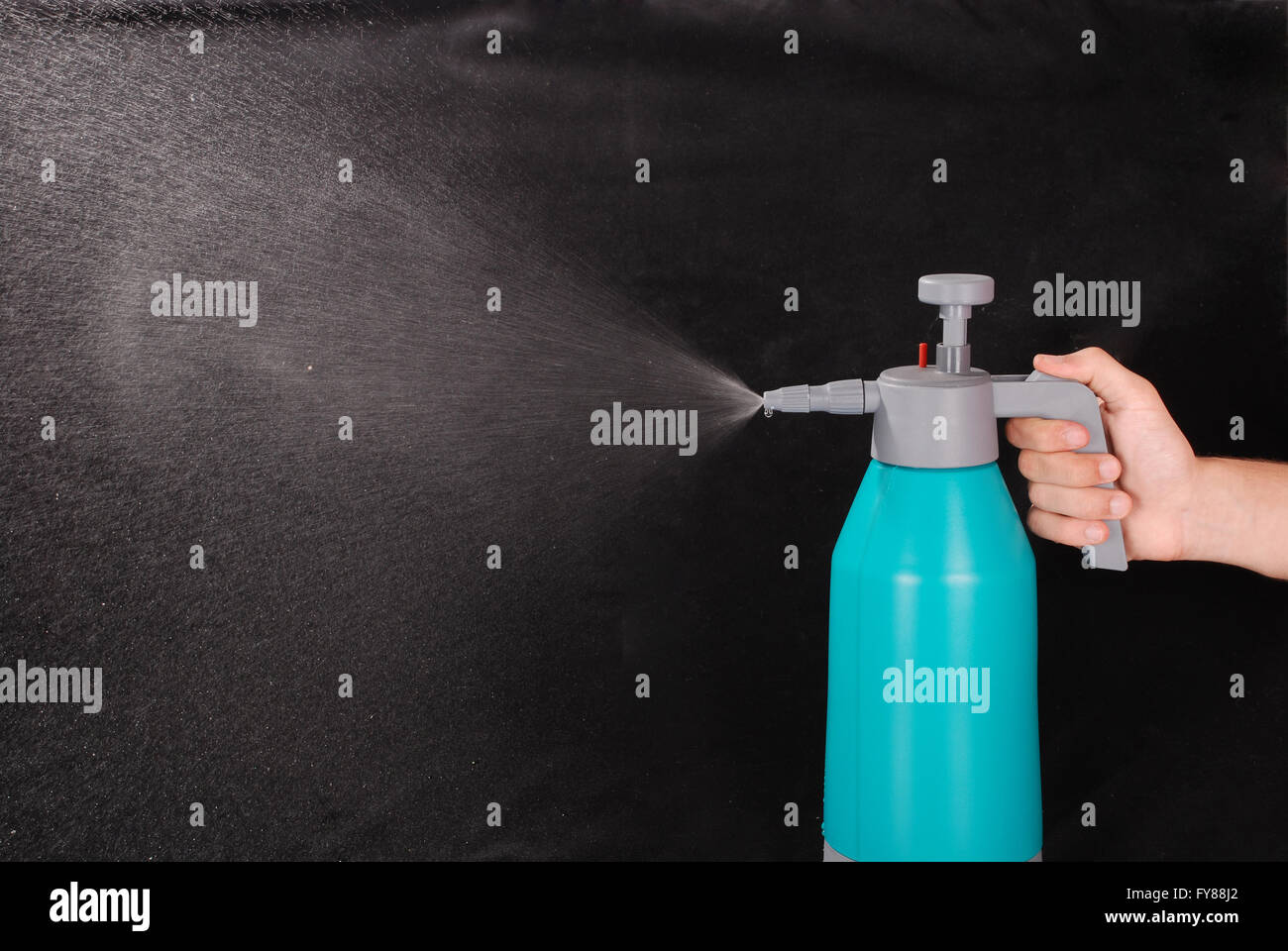 Male hand holding spray bottle isolated on black background Stock Photo ...