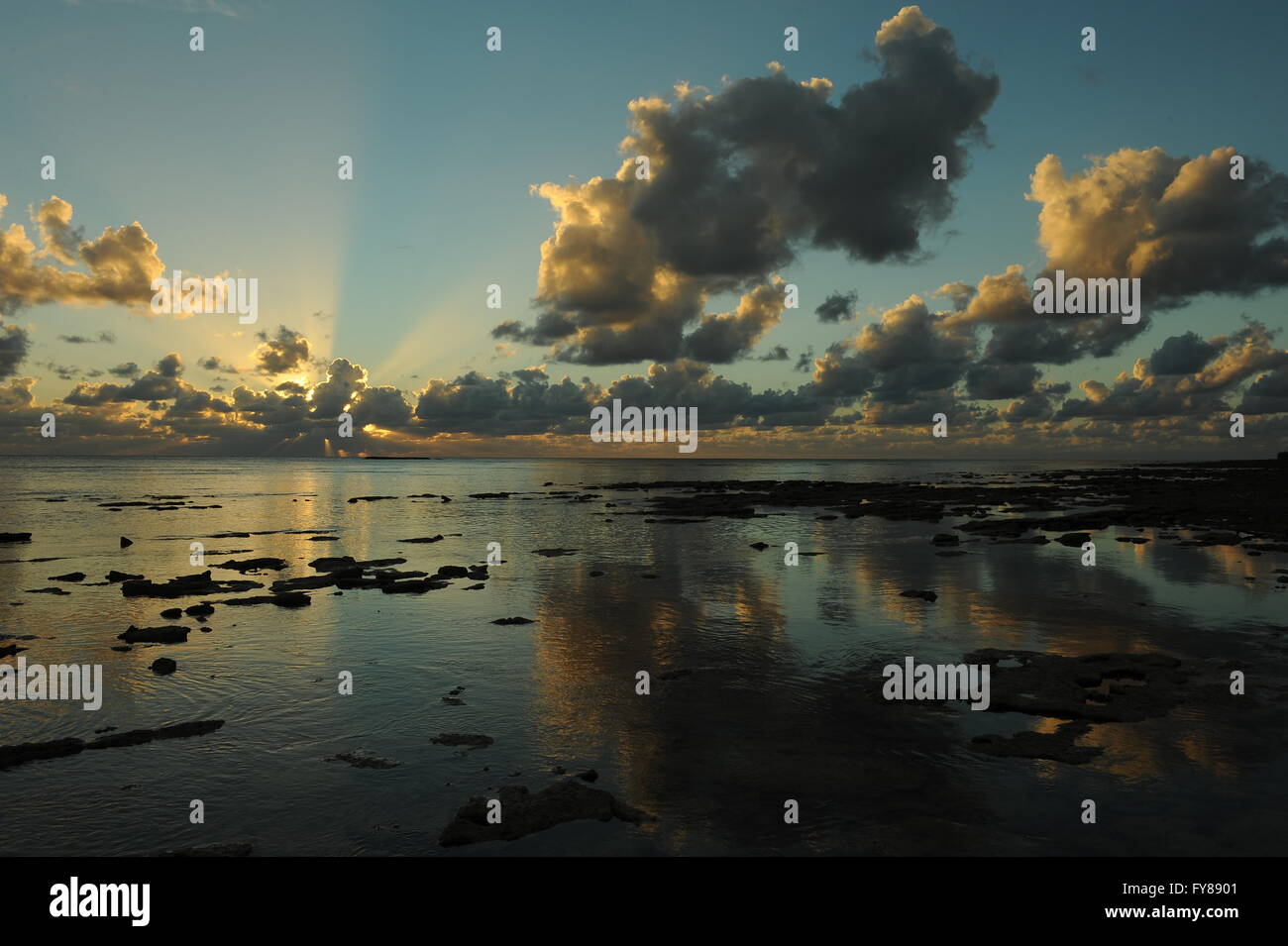 Sunset clouds over tropical island and reefs Stock Photo - Alamy