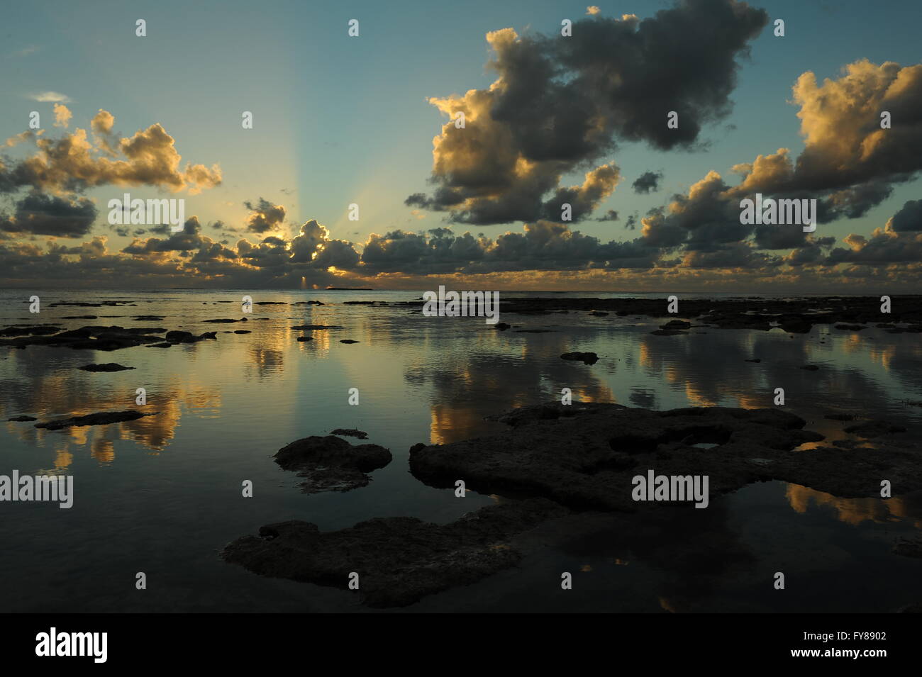 Sunset clouds over tropical island and reefs Stock Photo - Alamy