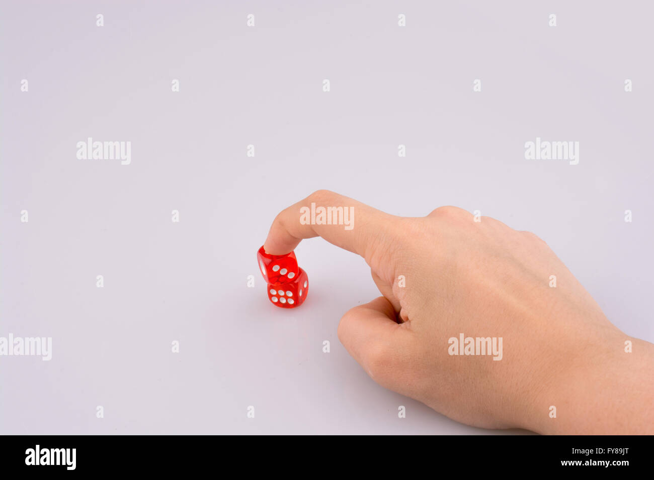 Hand holding red dice on a white background Stock Photo - Alamy