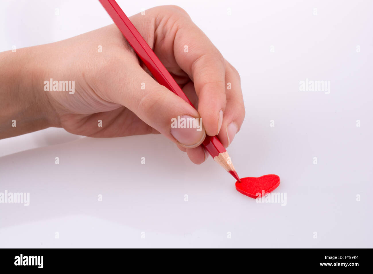 Pencil pointing a red heart Stock Photo - Alamy