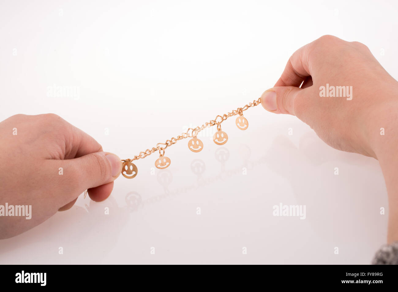 Golden color smileys arrayed on a chain in hand Stock Photo - Alamy