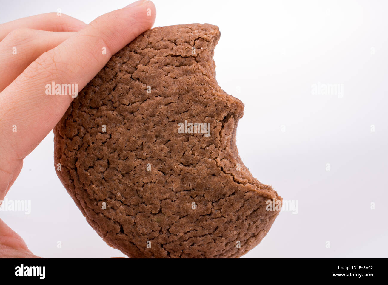 Hand holding bitten cookie on a white background Stock Photo - Alamy