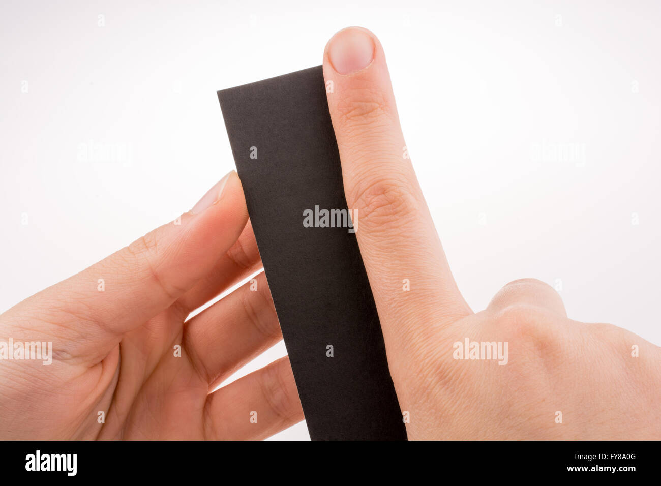 Hand holding a piece of black paper on a white background Stock Photo ...