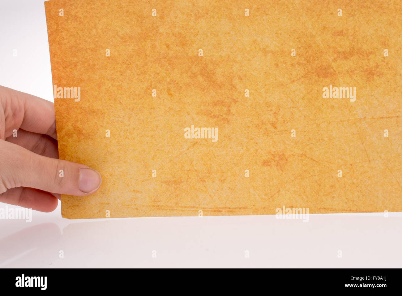 Hand holding a piece of paper on a white background Stock Photo - Alamy