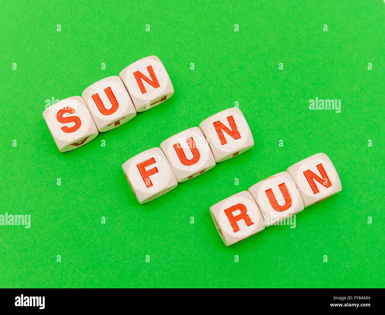 still life with dices and the word sun fun and run, green background ...