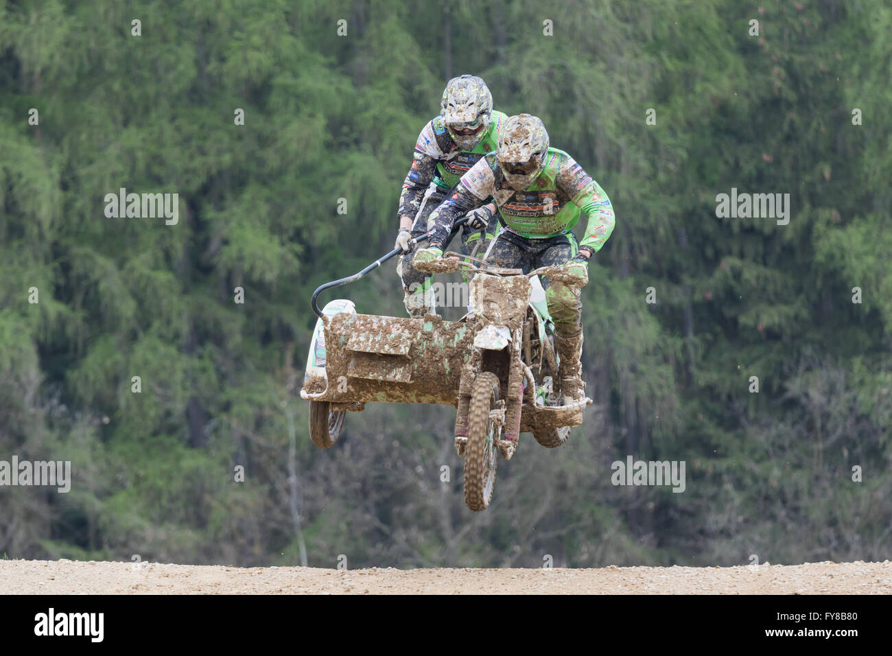 Two racers in green are jumping a sidecar in the race Stock Photo - Alamy